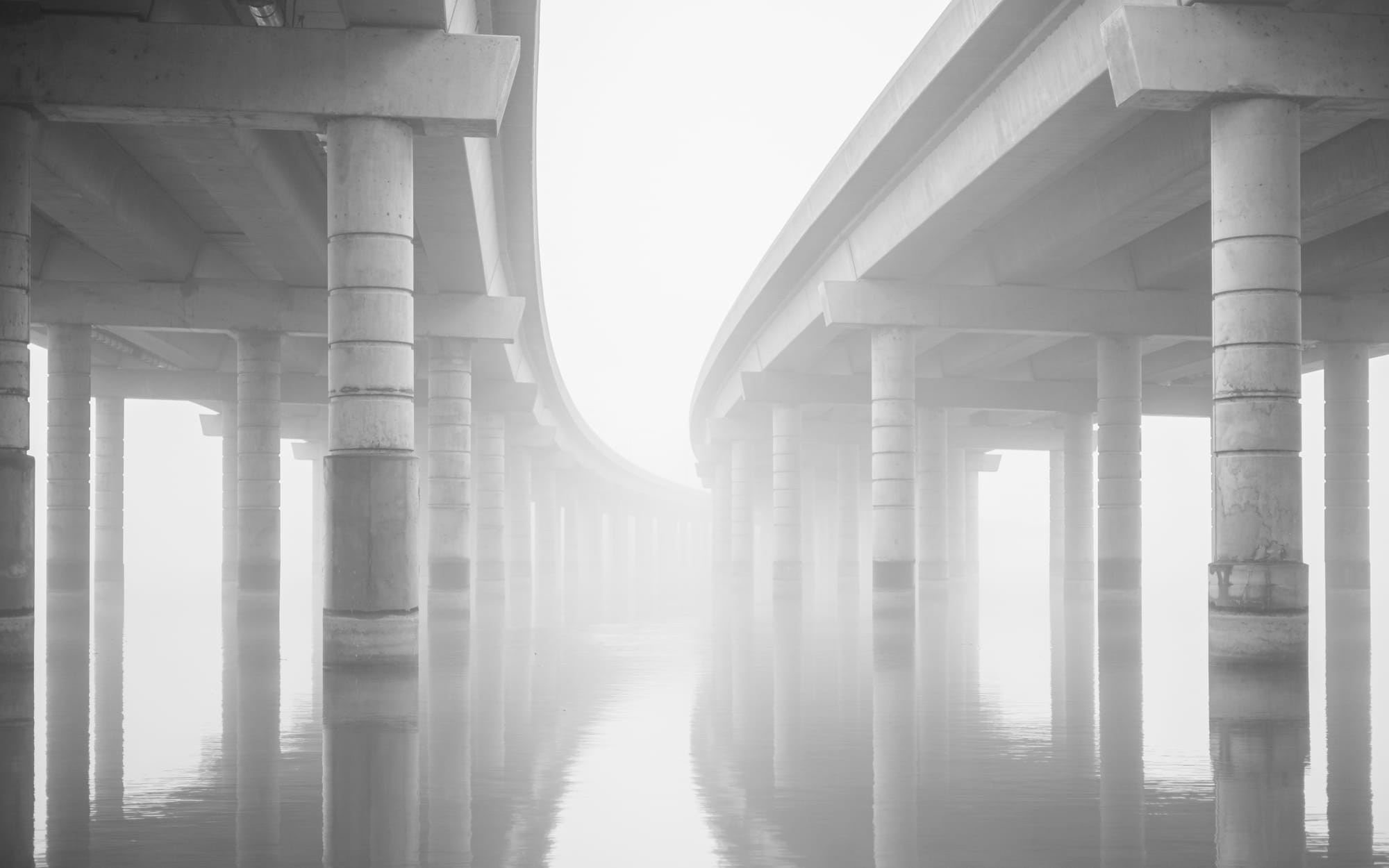 A Bridge In Fog Extending Into The Mysterious White Nothingness